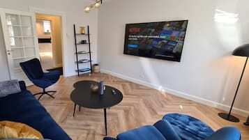 Apartamento | Sala de estar | Televisor de ecrã plano de 75 polegadas com canais por cabo, televisor