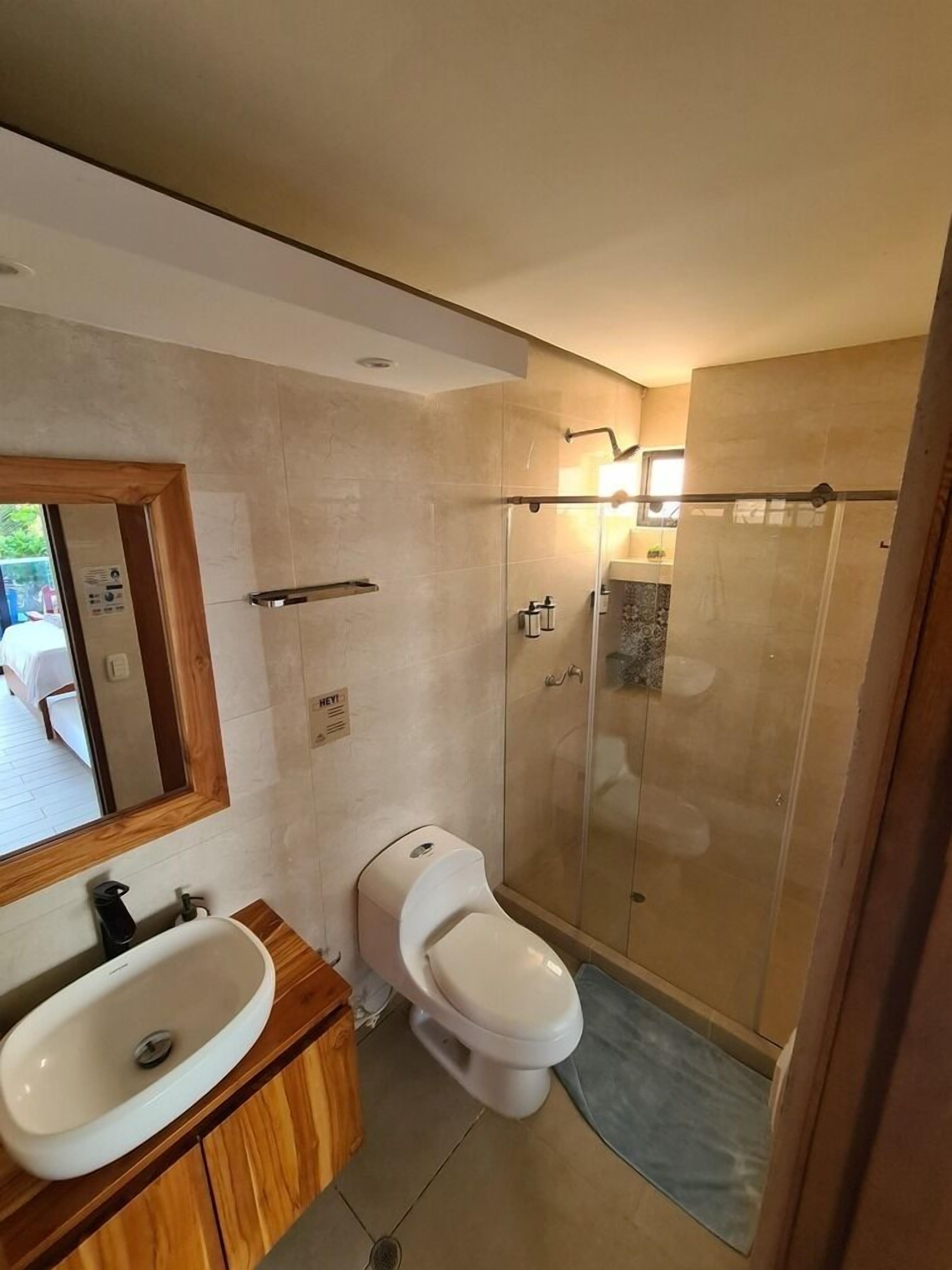 Uma casa de banho moderna com lavatório, sanita e cabine de duche com vidro.