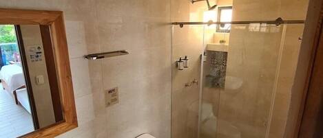 Uma casa de banho moderna com lavatório, sanita e cabine de duche com vidro.