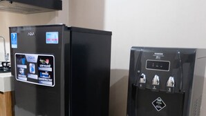Uma geladeira preta com dispensador de água e painel de controle.