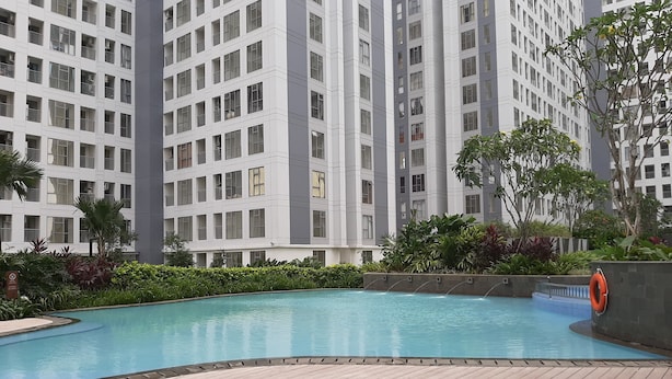 Um edifício residencial moderno com área de piscina.