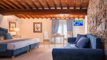Um quarto com uma cama, dois sofás, uma mesa e cadeiras.