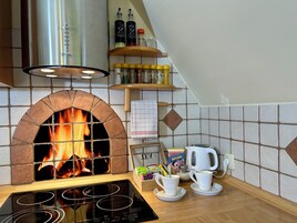 Uma cozinha com forno de tijolos embutido, fogão e cafeteira.