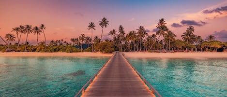 Na praia, areia branca, espreguiçadeiras, guarda-sóis