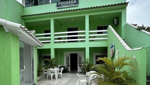 Um edifício verde com uma placa que diz "POUSADA CAMINHO DO PONTAL".