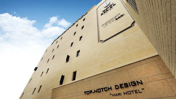 Exterior do Hotel Mari Design Top Notch, com céu claro e design arquitetônico moderno.