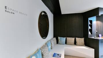 Um interior moderno com uma receção branca, uma parede de destaque preta e um espelho decorativo.