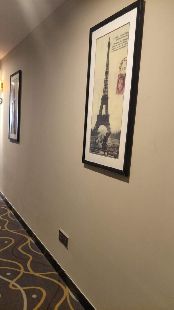 Corredor com quadros emoldurados da Torre Eiffel na parede.