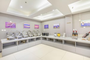 Quarto de hotel moderno com balcão extenso, vários espelhos e seleção de artigos de higiene pessoal.
