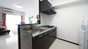 Apartamento Deluxe, 1 quarto | Cozinha privada | Um frigorífico, um micro-ondas, uma placa de cozinha