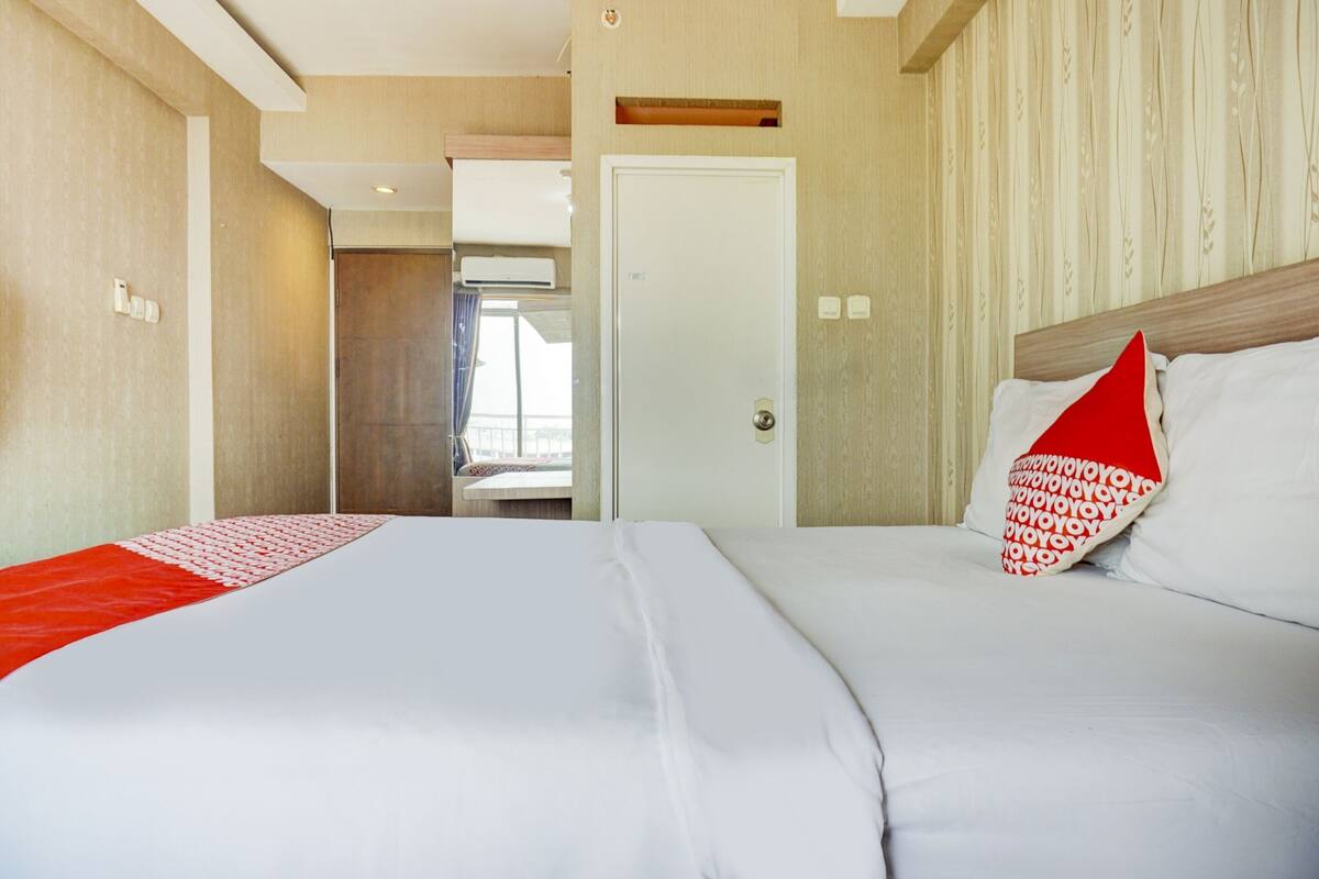 Quarto de hotel com duas camas, uma porta e uma janela.