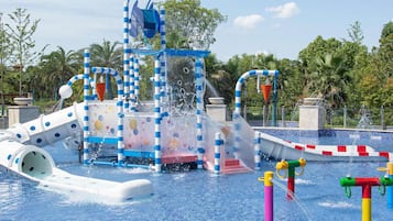 Parque aquático com toboáguas, jatos d'água e piscina.