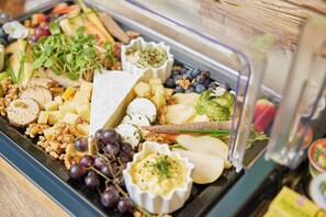 Tábua de frios com diversos queijos, frutas, nozes e patês.