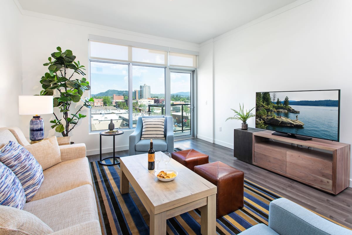 Uma sala de estar moderna com um sofá, mesa de centro e aparador para televisão.