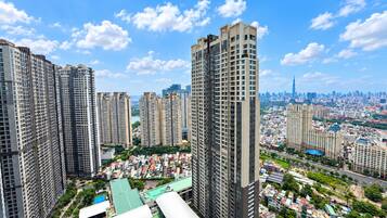 Um complexo de edifícios residenciais altos, com vários prédios de apartamentos, rodeado por casas menores e vegetação.
