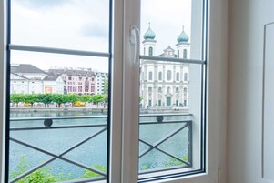 Uma janela com vista para um corpo d'água e edifícios com cúpulas.