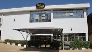 Um edifício com uma placa que diz 'Café' sobre a entrada.