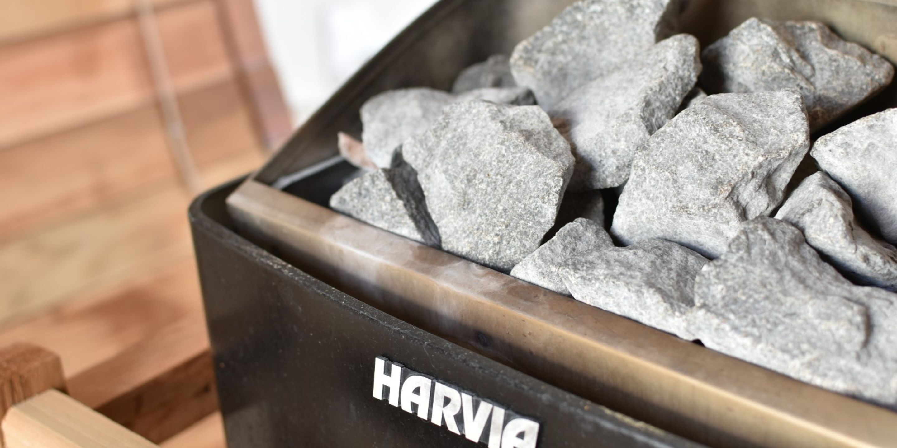 Um recipiente com a inscrição "HARYVA" cheio de pedras cinzentas.