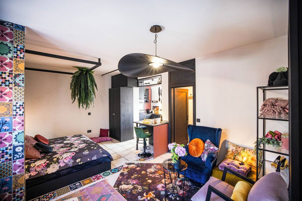 Um espaço compacto com cozinha compacta, área de refeições e sala de estar com sofá e poltrona.