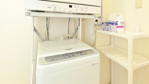Uma sala médica com um armário branco, um esterilizador e uma prateleira com material médico.