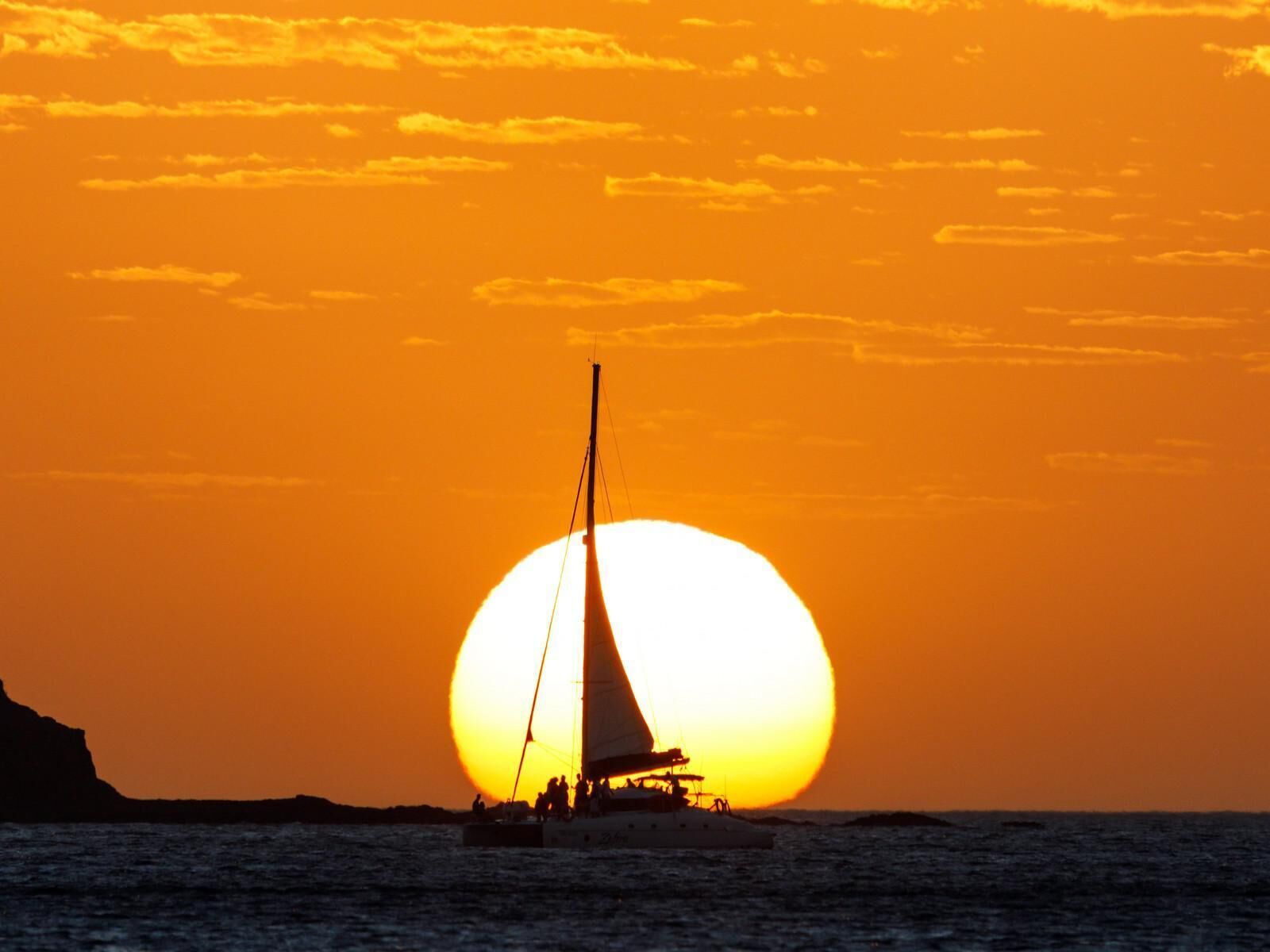 Um veleiro em águas calmas durante o pôr do sol.