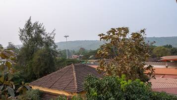Uma área residencial com casas, árvores e uma colina ao longe.