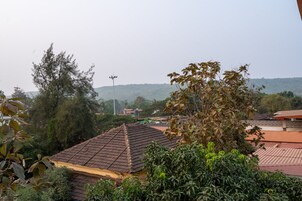 Uma área residencial com casas, árvores e uma colina ao longe.