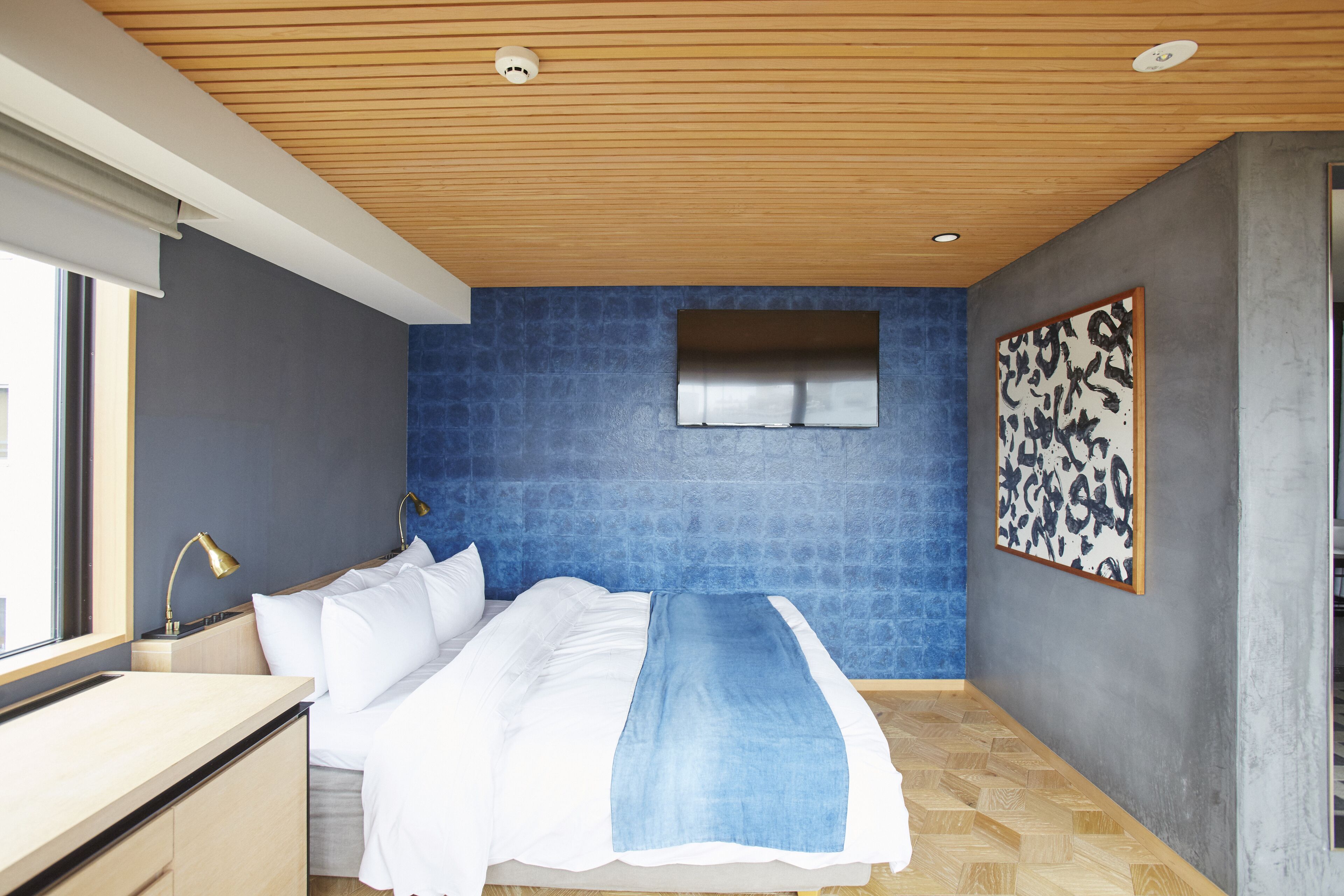 Quarto moderno com uma cama, uma escrivaninha e uma janela.