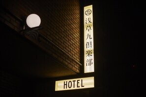 Placa de hotel com caracteres japoneses e a palavra 'HOTEL' abaixo.