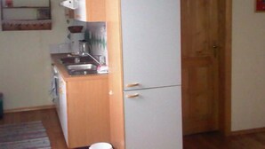 Apartamento | Kitchenette privada | Um frigorífico, uma placa de cozinha, utensílios de cozinha