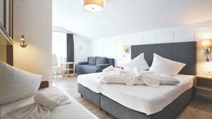 Quarto de hotel moderno com uma cama grande, um sofá e uma mesa de escritório.