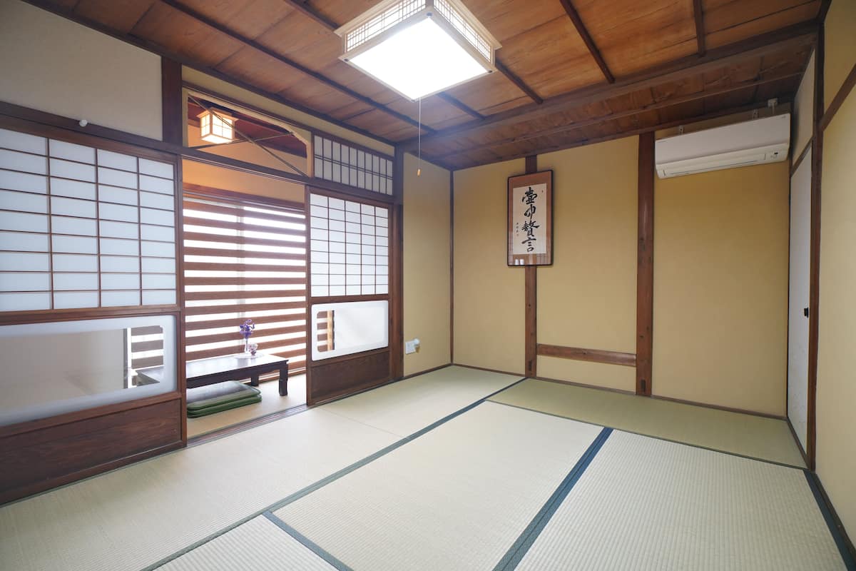 Um quarto japonês tradicional com tatames, portas deslizantes e um biombô shoji.