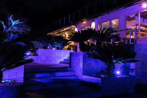Um edifício com design moderno, com uma escadaria que leva a um espaço de bar com assentos.