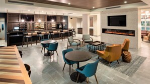 Uma sala de estar moderna com um bar, assentos e uma lareira.