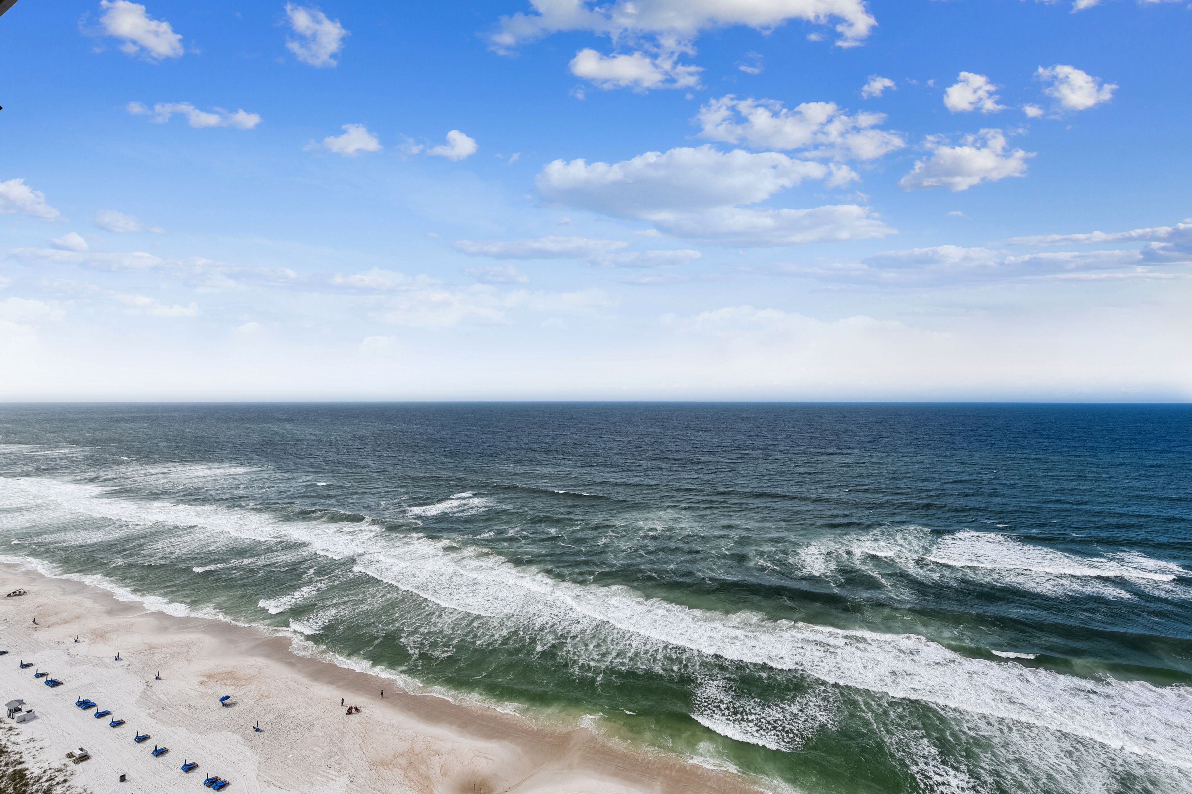 Uma praia com ondas e céu claro.