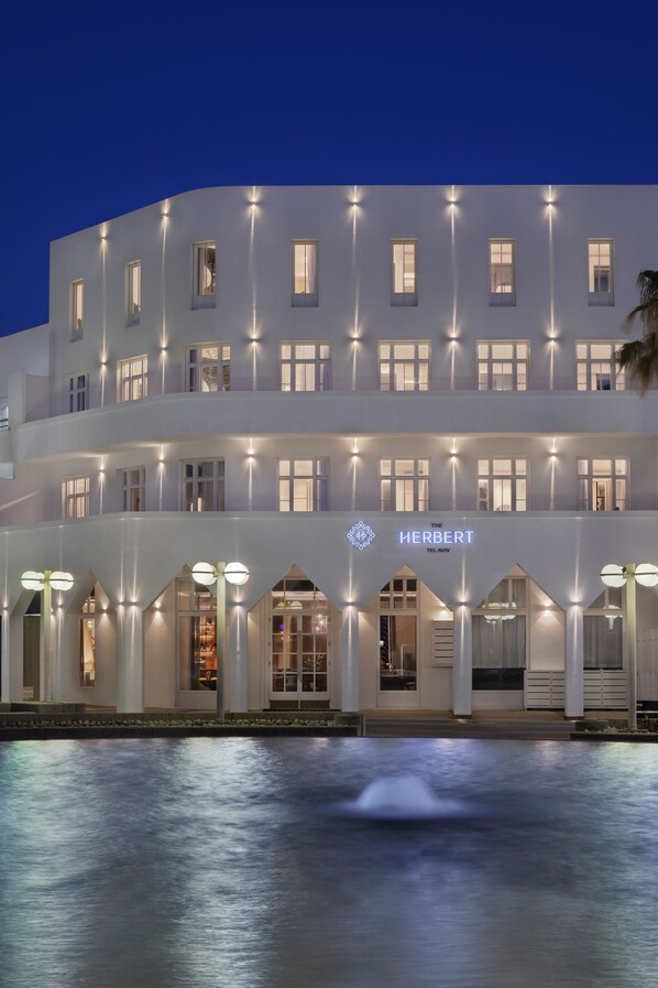 Um hotel com vários andares e piscina em primeiro plano.
