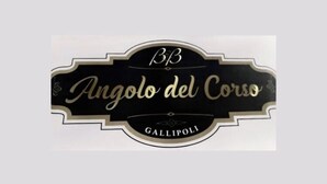 Placa preta e dourada com o texto 'Angolo del Corso' e 'GALLIPOLI', indicando um local ou estabelecimento.