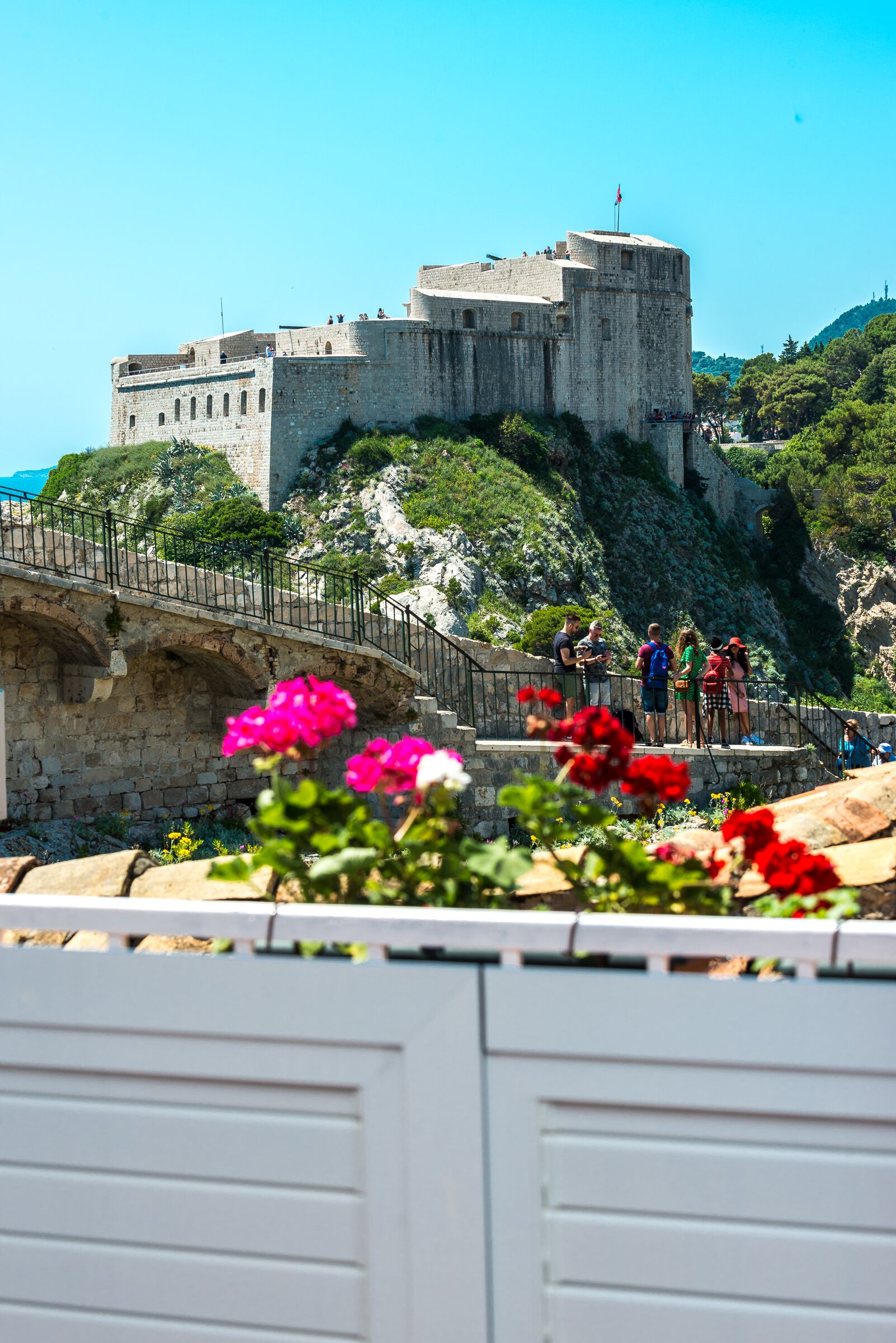 Um castelo de pedra histórico com uma muralha fortificada e uma ponte que o leva.