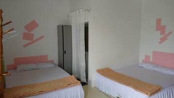 Quarto com duas camas, cada uma com colcha branca e manta cor de pêssego. Há uma cortina branca em uma porta e uma parede branca com padrões geométricos rosa.