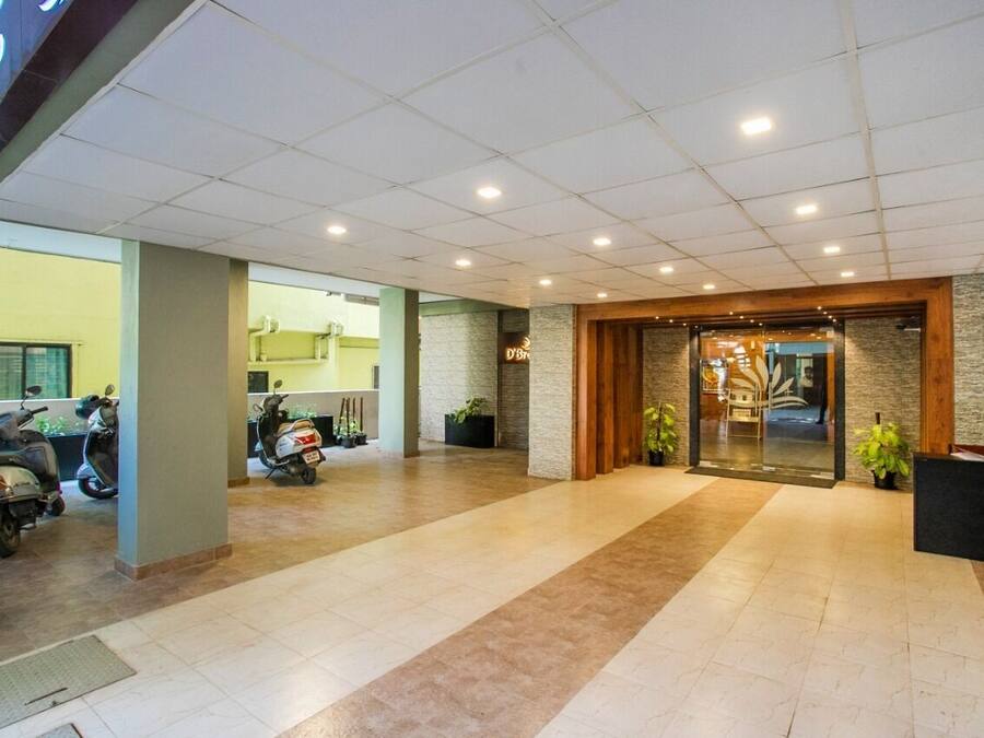 Um hall de hotel com uma recepção, uma área de estar e alguns scooters estacionados.