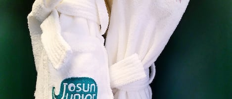 Um roupão branco com a inscrição 'Grand Josun' e o logotipo 'Josun Junior'.