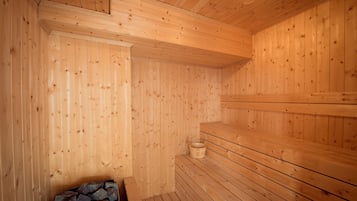 Uma sauna de madeira com bancos e um banco de madeira.