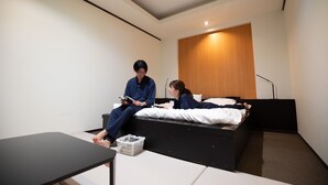Quarto moderno com uma cama, uma mesinha e um cesto branco.