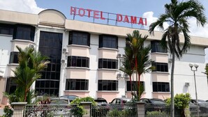 Um edifício de hotel com uma placa que diz 'HOTEL DAMAI'.