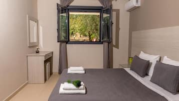 Quarto com cama, mesa de cabeceira, espelho e janela aberta com cortinas.