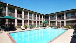 Um hotel com piscina, várias varandas e espreguiçadeiras.