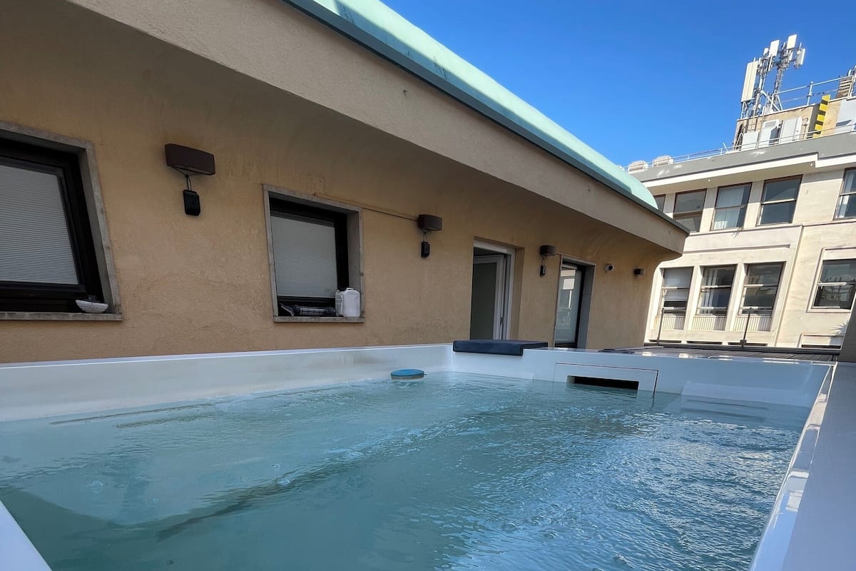 Piscina no terraço com um céu azul e límpido ao fundo.
