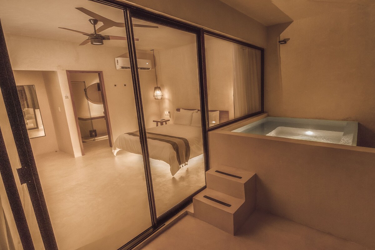 Uma casa de banho moderna com chuveiro em cabine de vidro, um espelho grande e uma banheira de hidromassagem integrada.