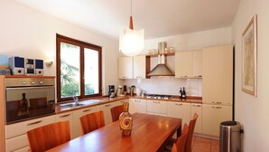Uma cozinha moderna com mesa de jantar de madeira, eletrodomésticos embutidos e vista para o exterior.