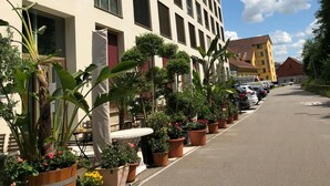Um edifício de vários andares com arquitetura moderna, apresentando uma série de varandas e janelas amplas.